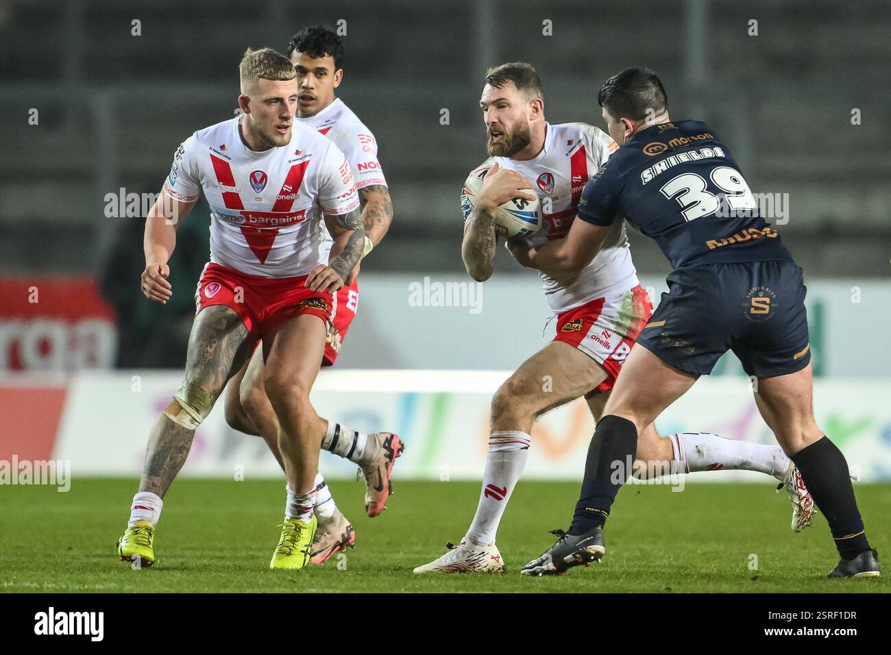 Daryl Clark of St. Helens is tackled by James Shields of Salford Red ...