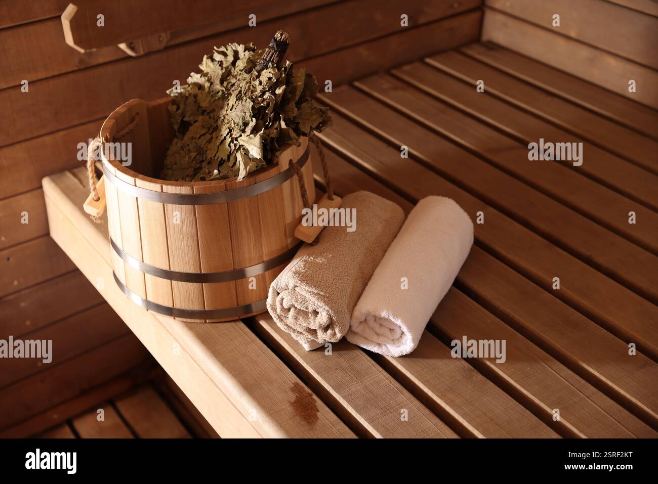 Bucket, whisk and towels on wooden bench in sauna Stock Photo - Alamy
