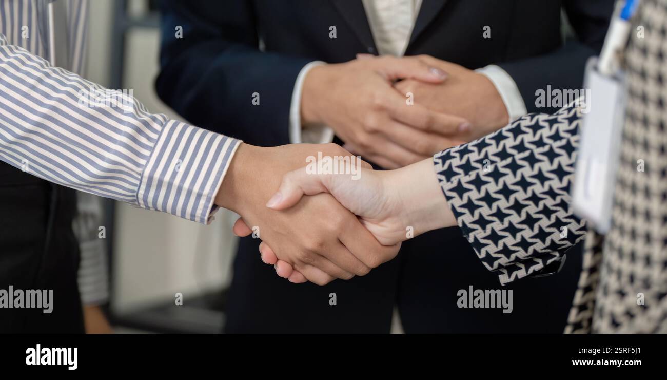 Diverse business professionals shaking hands to celebrate a successful ...
