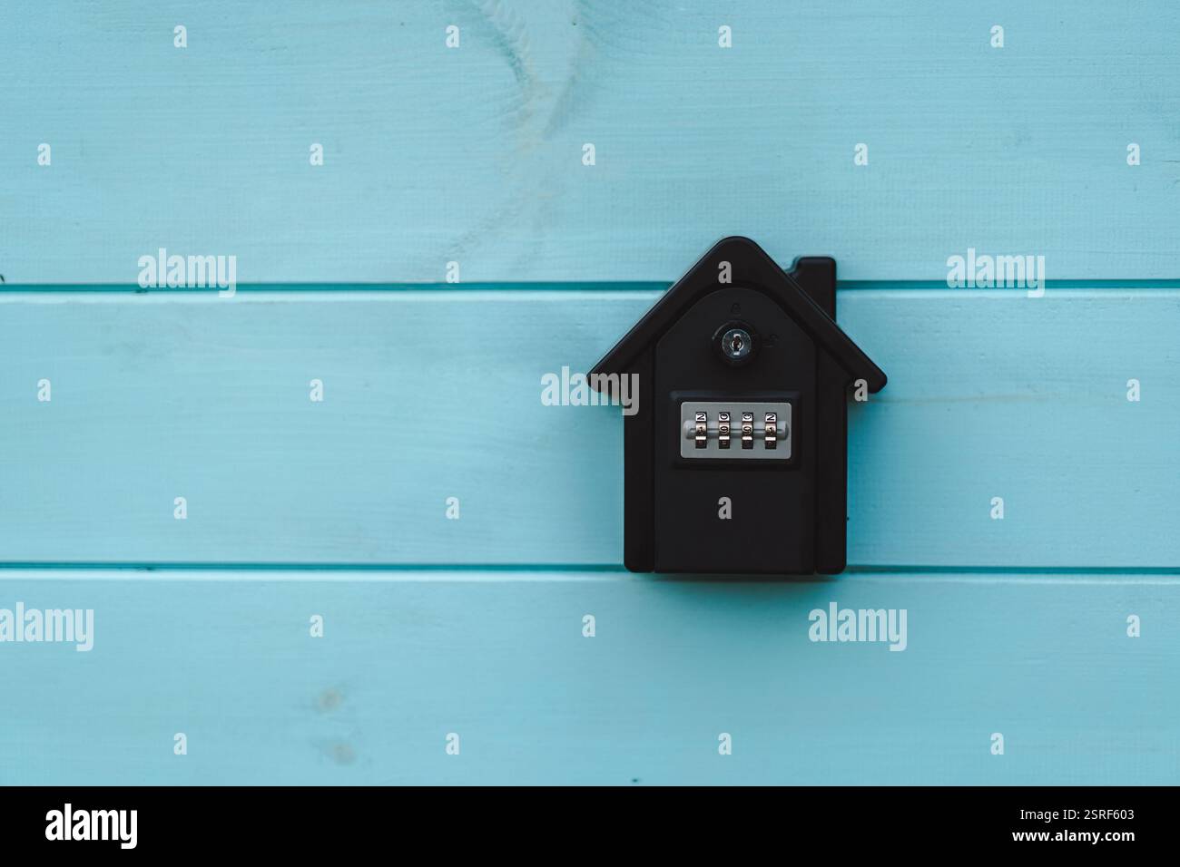 Combination lockbox mounted on a blue wooden wall Stock Photo - Alamy