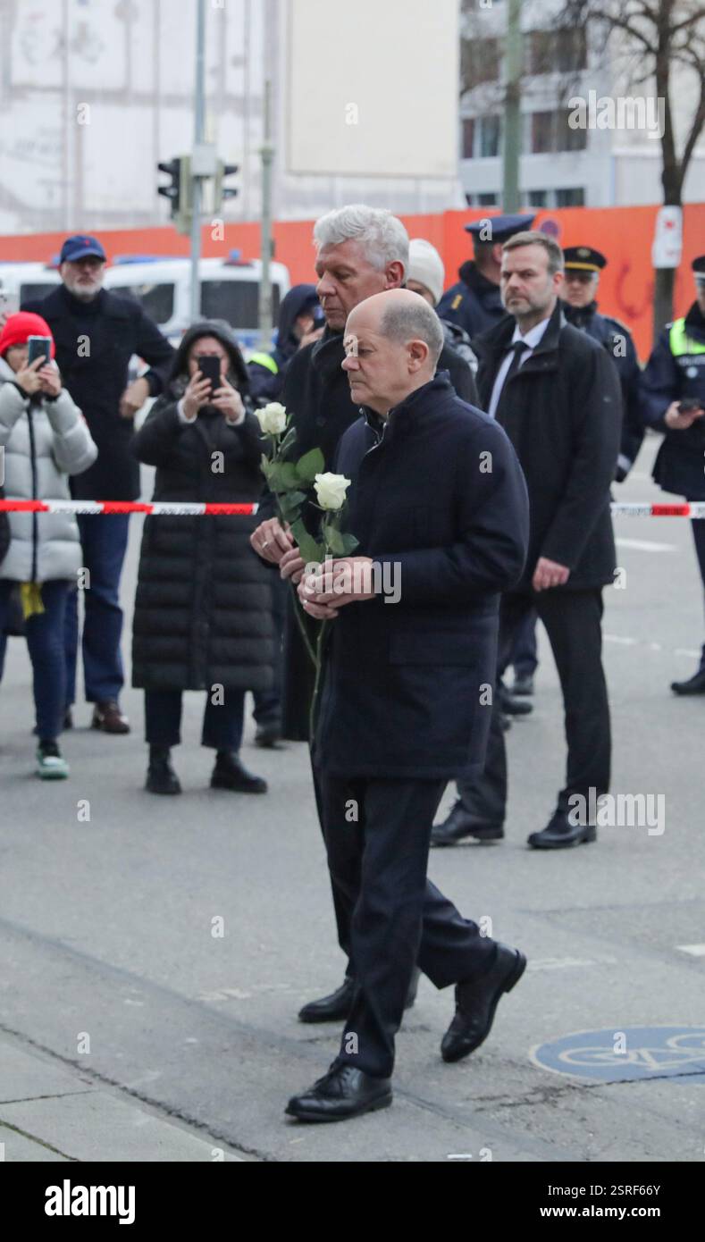 Munich, Germany. 15th Feb, 2025. German Chancellor Olaf Scholz lays flowers at the site of a car ...