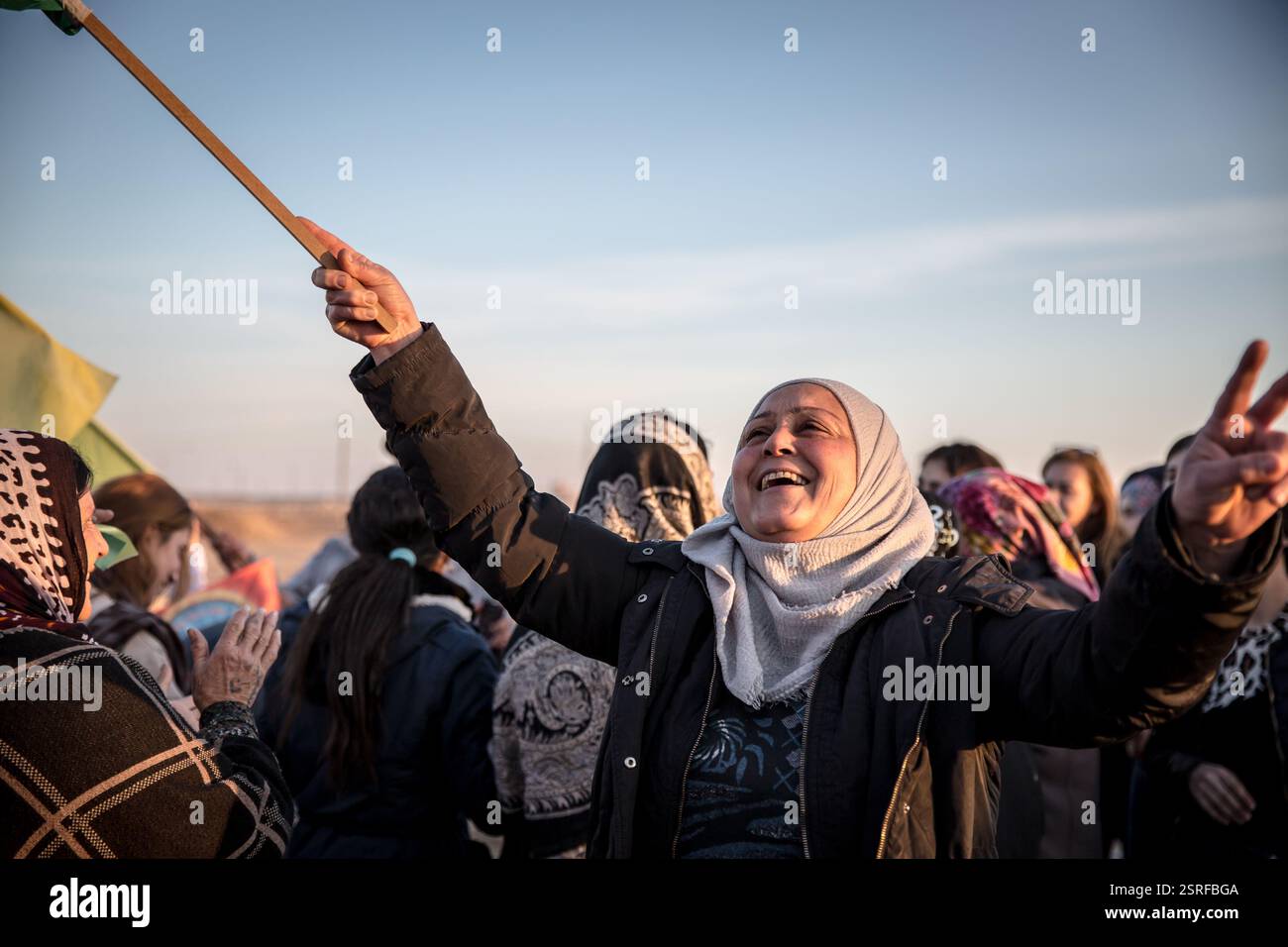 Hasaka, Syria. 15th Feb, 2025. A woman waves a YPG flag as friends and family members welcome ...