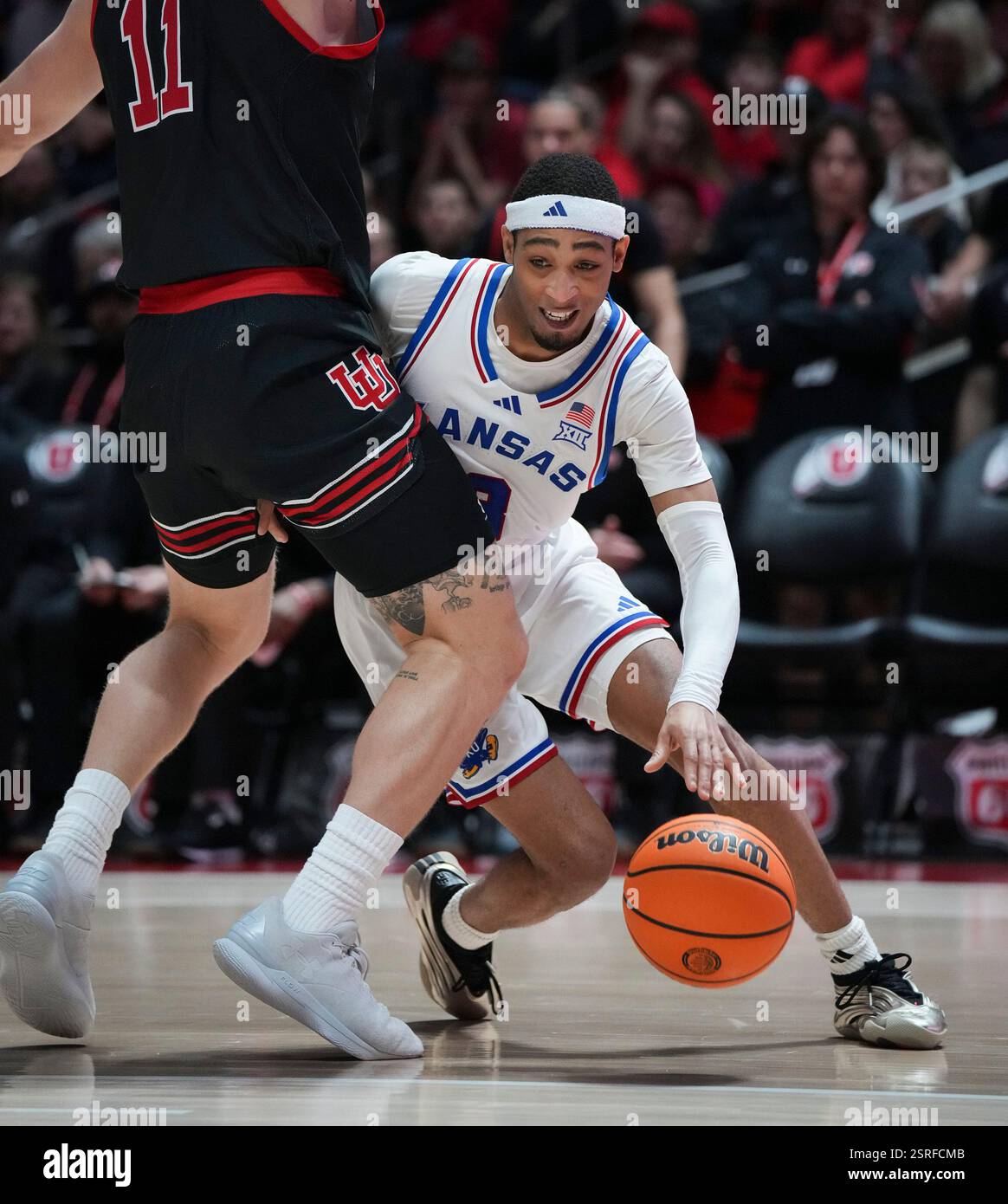 Kansas guard Dajuan Harris Jr., behind, drives to the basket as Utah ...