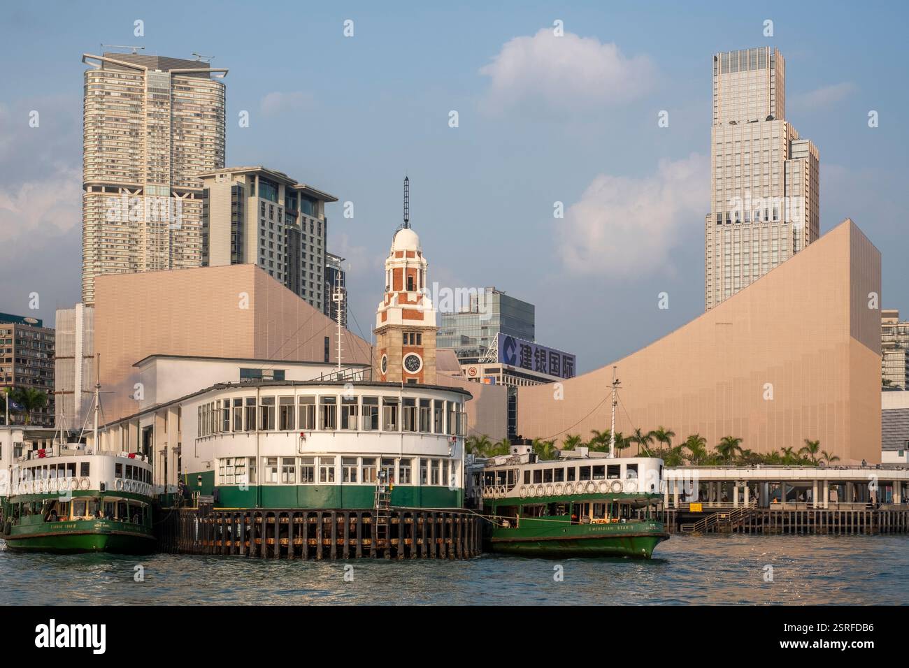 Scenic view from the water towards Tsim Sha Tsui, showcasing the historic pier, two parked star ...
