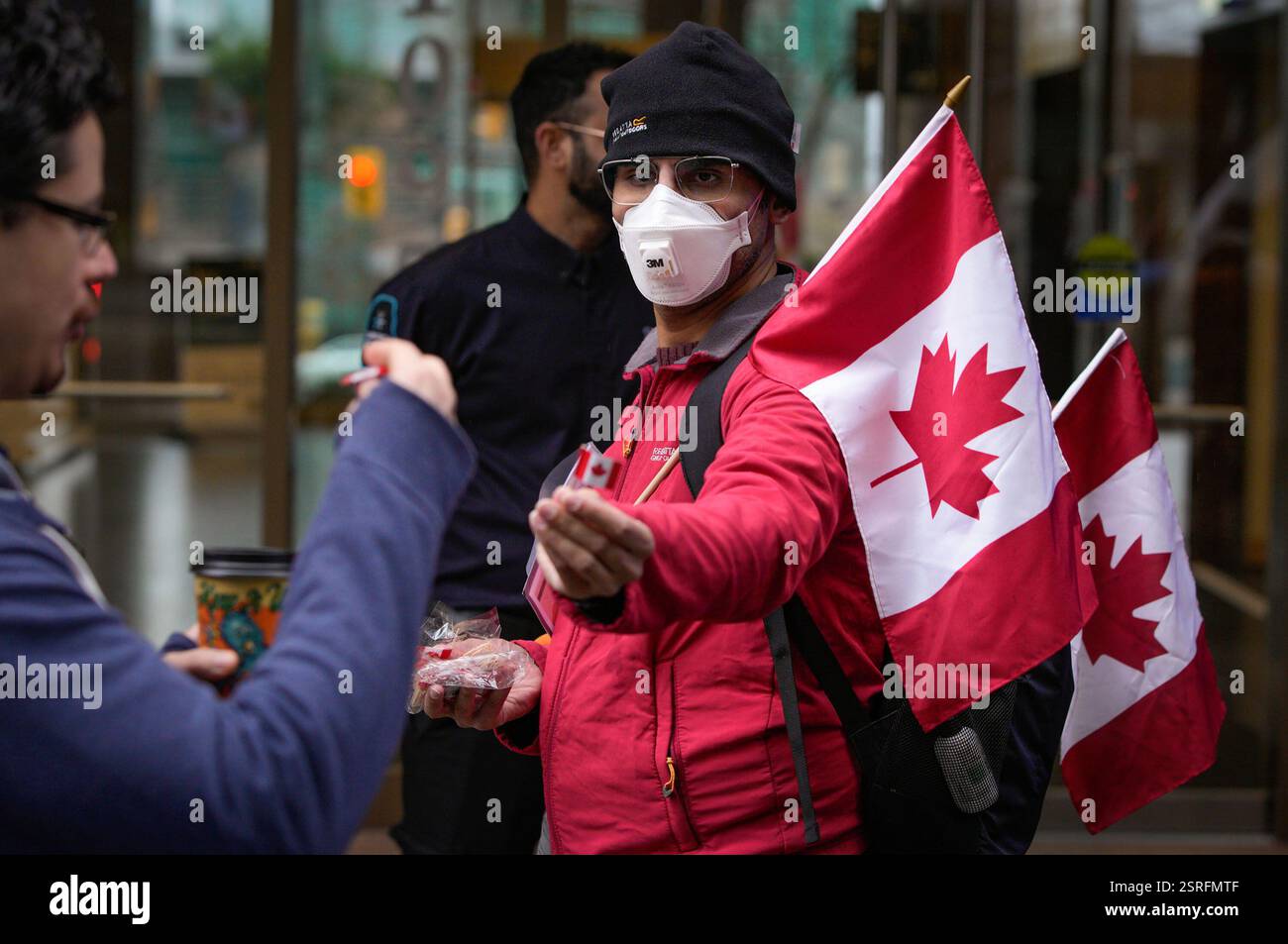Vancouver, Canada. 15th Feb, 2025. A man distributes mini Canadian ...