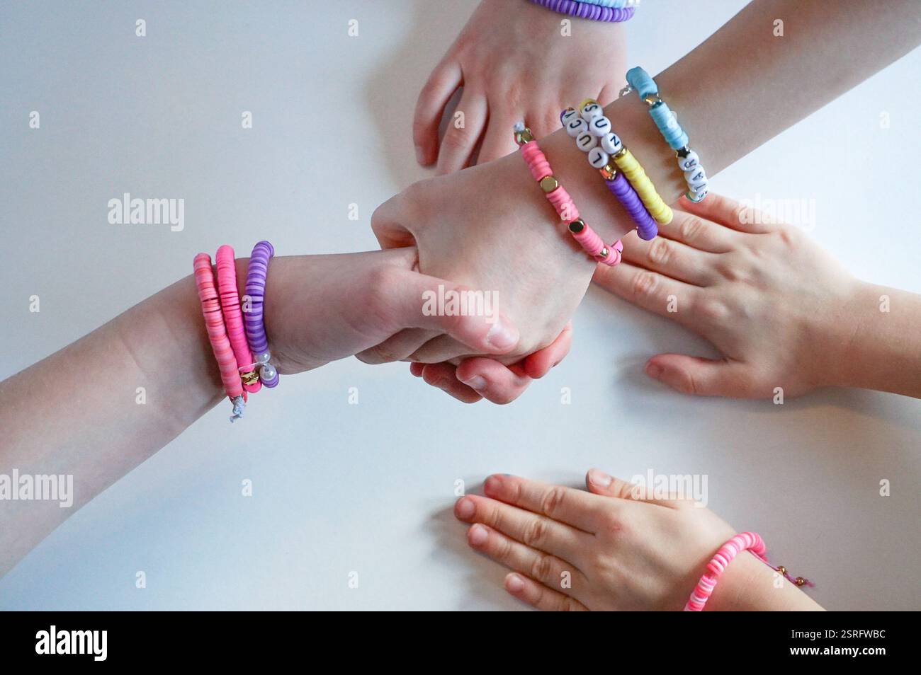 Holding hands. White background and friendship bracelets Stock Photo ...