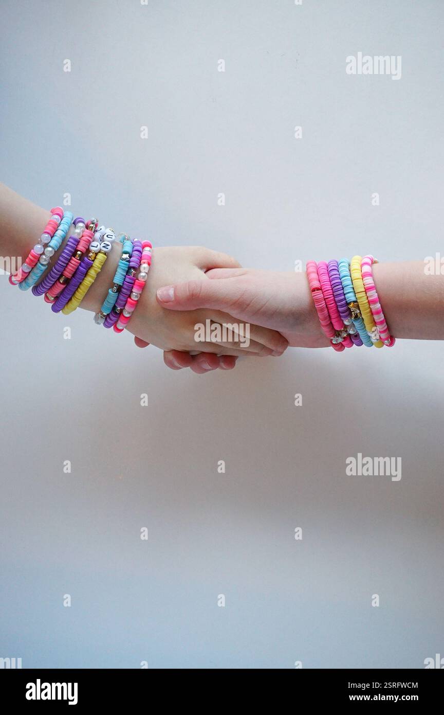 Holding hands. White background and friendship bracelets Stock Photo ...