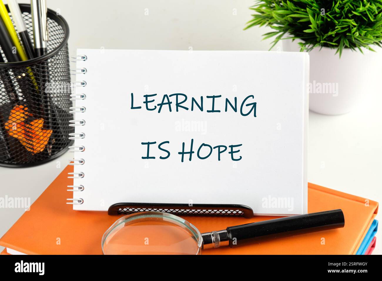 A notepad with the phrase learning is hope is prominently placed on an ...