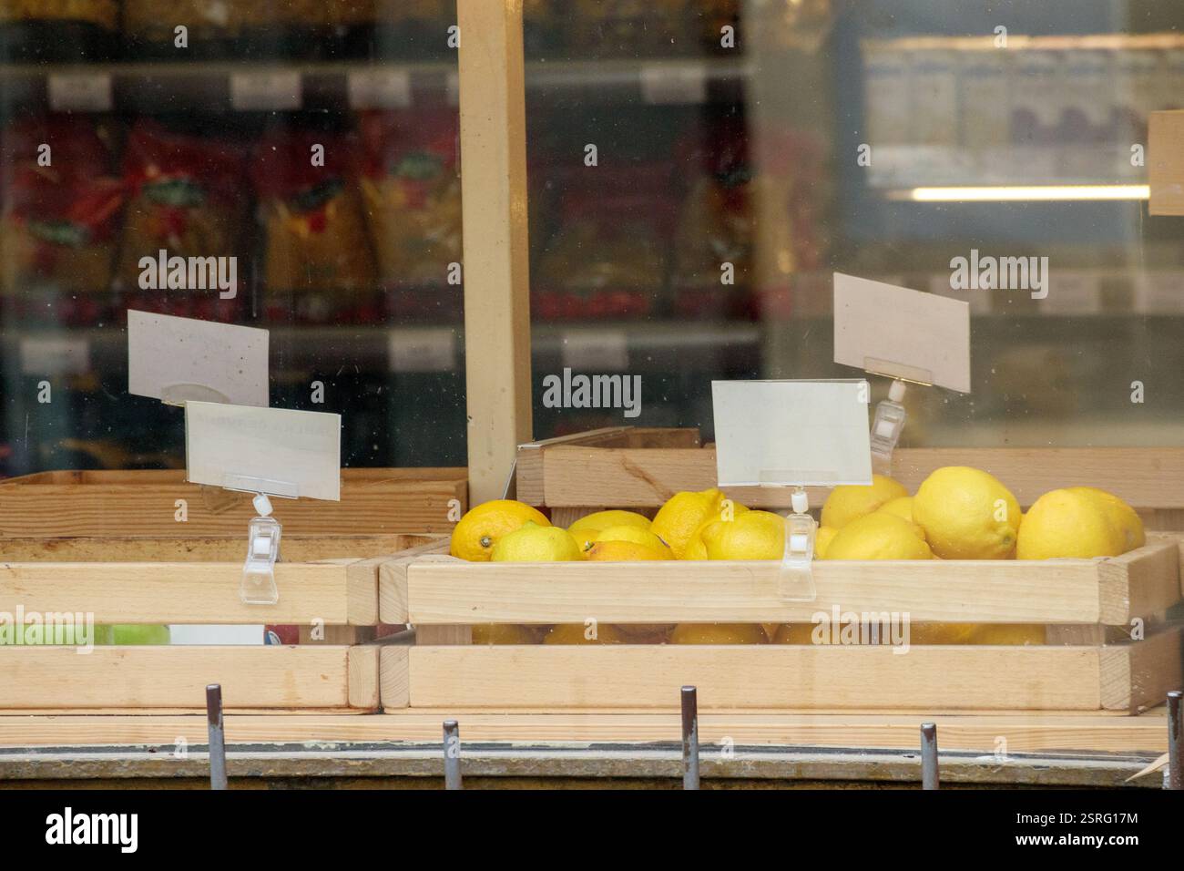 yellow lemons stacked in boxes with blank signs, perhaps for price or ...