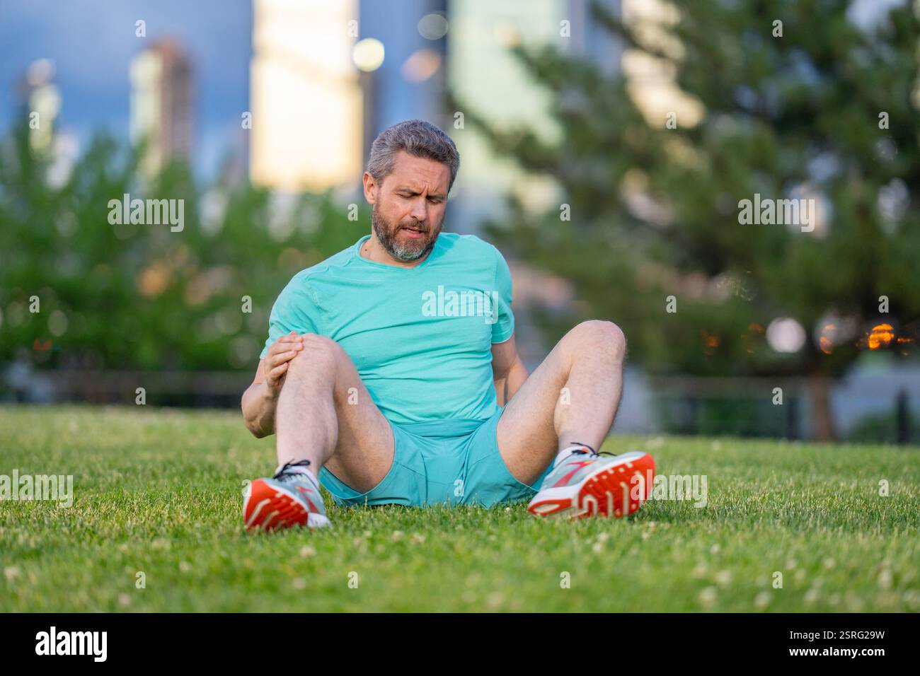 Broken knee after workout. Leg hurt during jogging. Injured man holding ...
