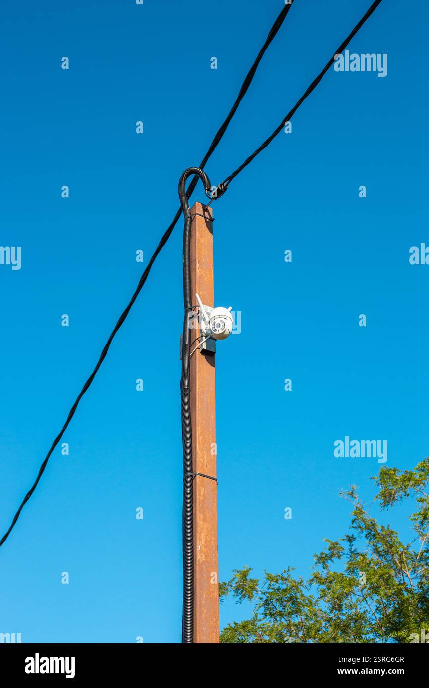 CCTV camera on a pole with electric wires. Security and surveillance of ...