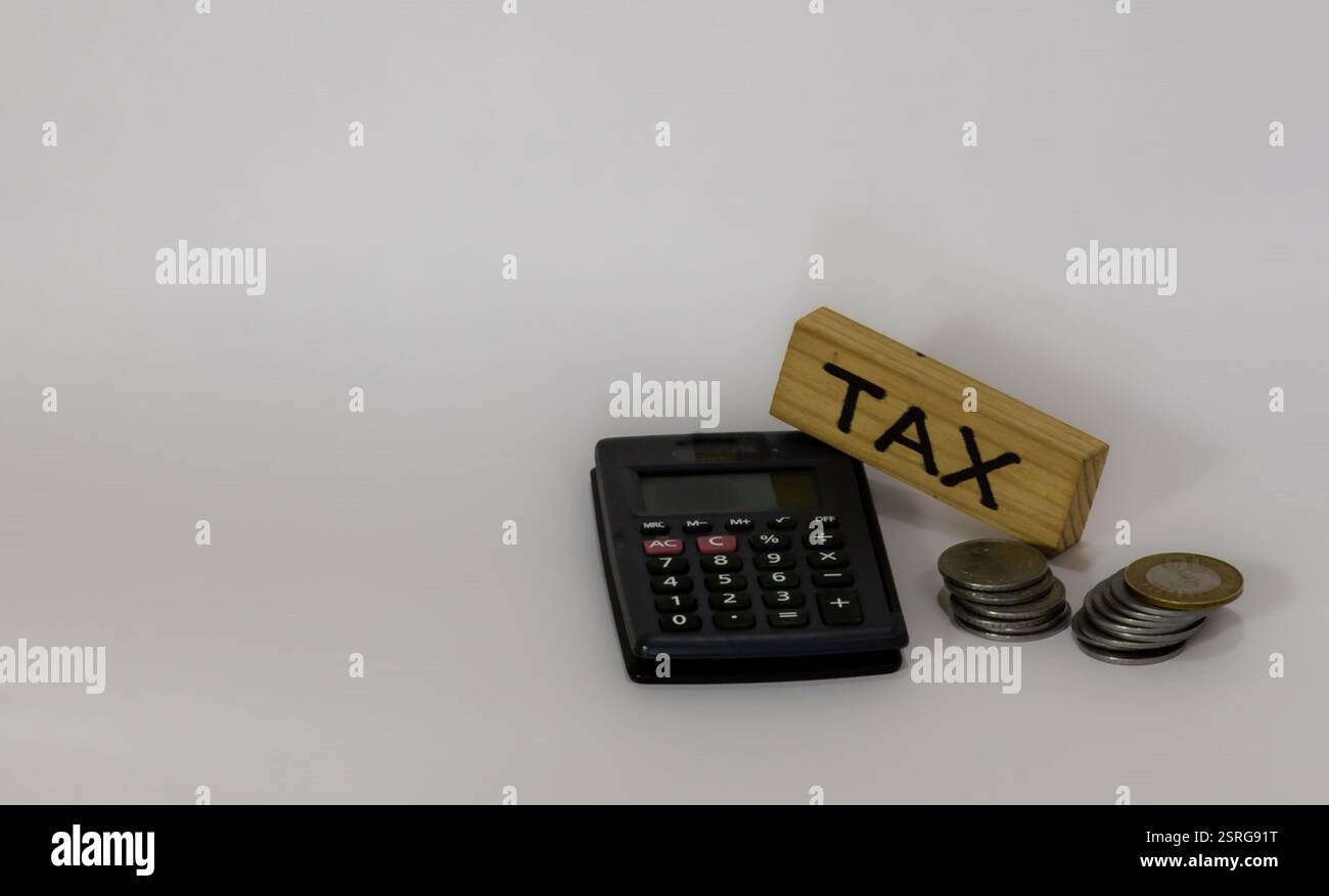 The image shows a black calculator, a wooden block with the word "TAX ...