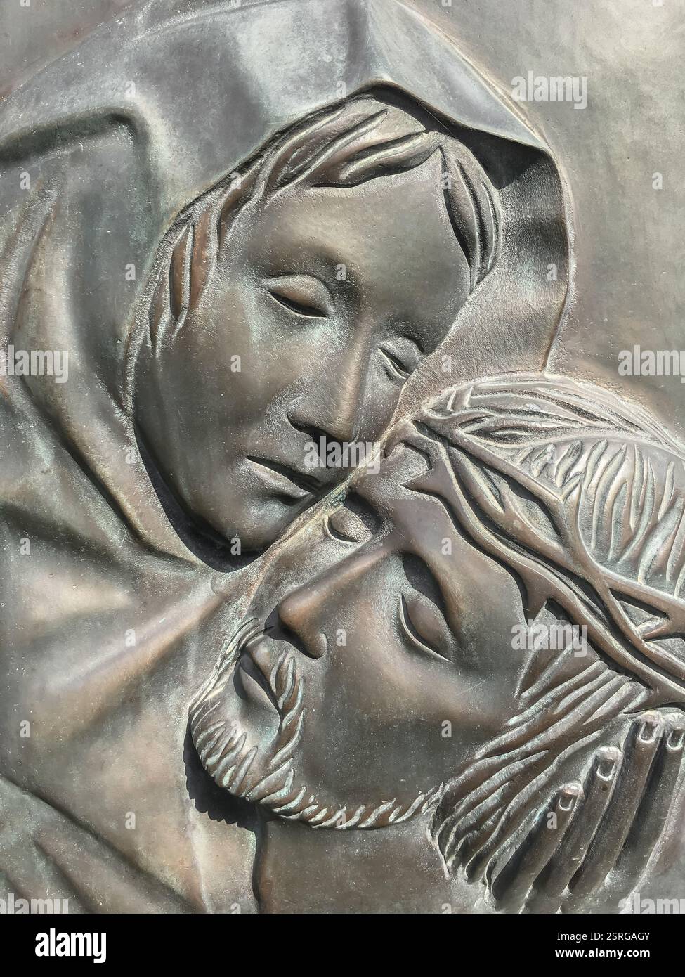 Bronze relief of dead Jesus Christ down from the cross and the Virgin Mary. Easter and religion ...