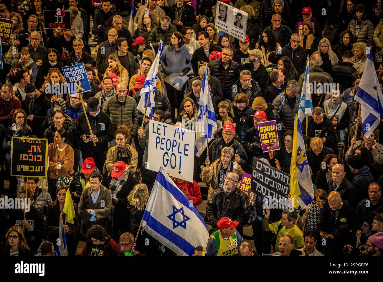 Israeli protestors hold up signs calling for the release of all ...