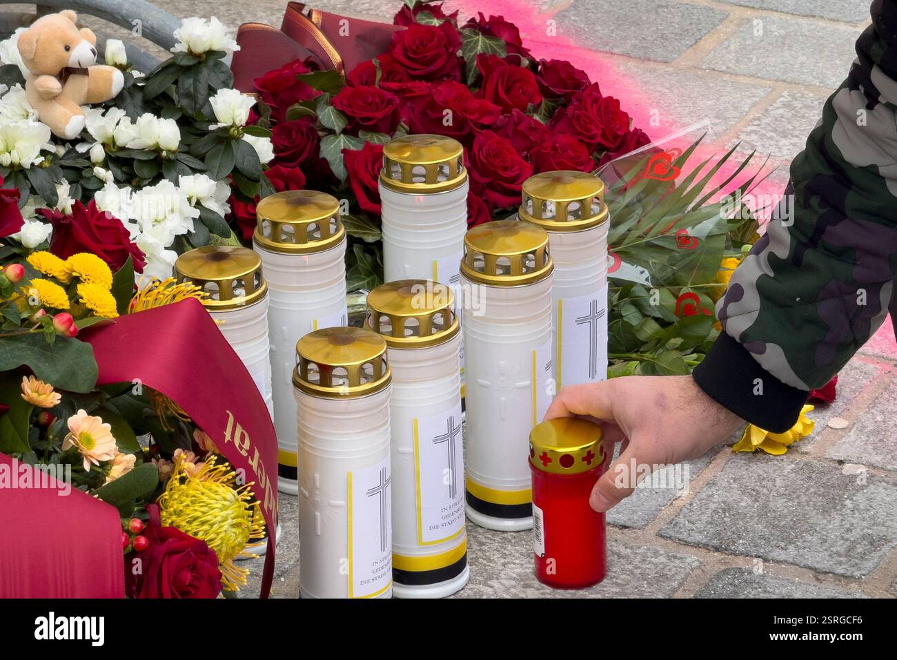 A man lights a candle at the site of stabbing a day after an attack ...