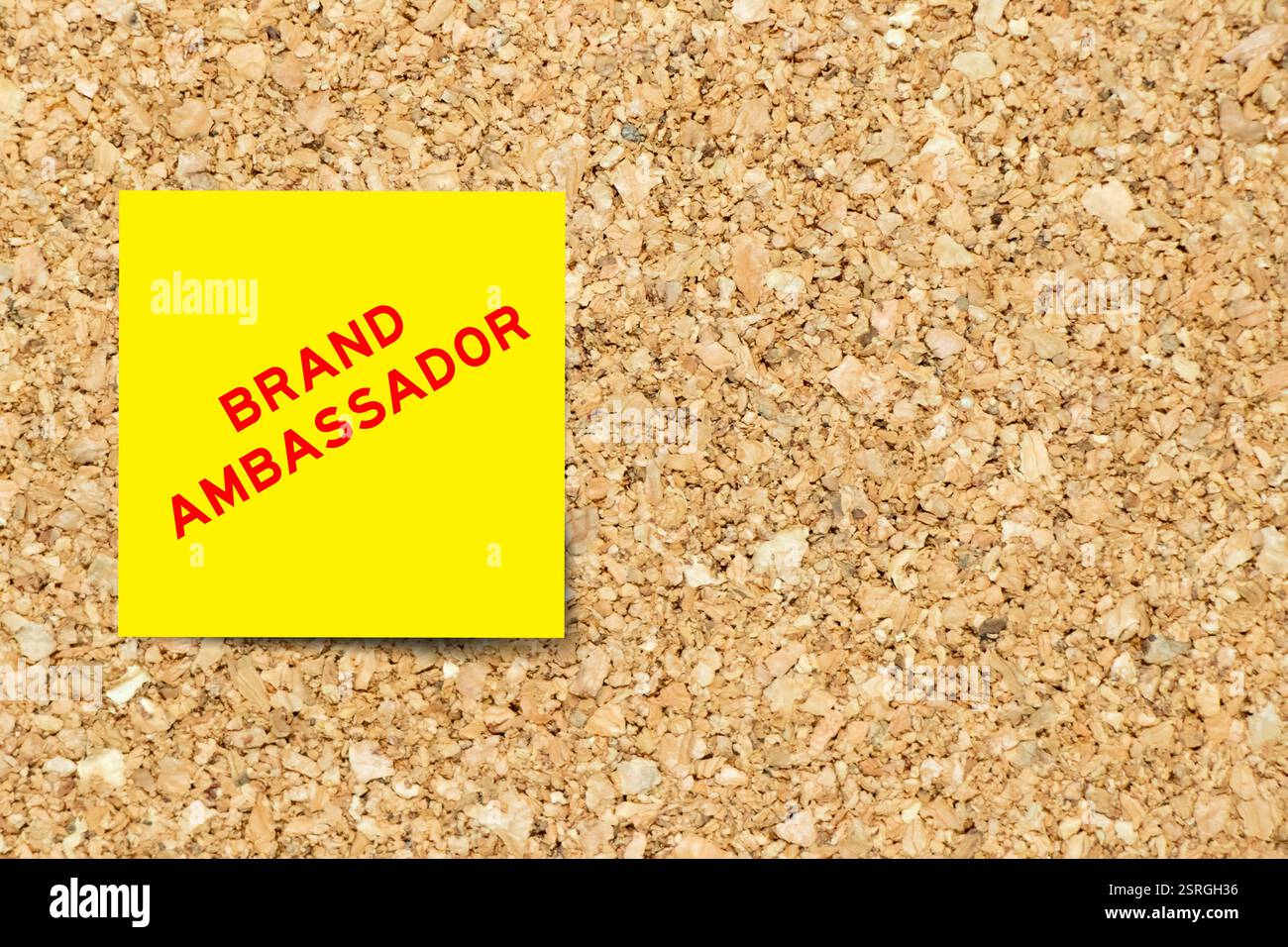 Yellow note paper with word brand ambassador on cork board background ...