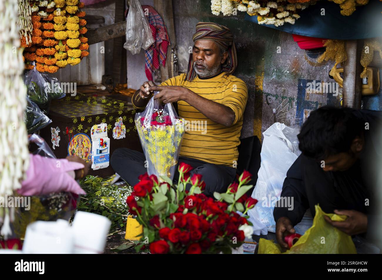 Vendor makes rose bouquet to sell in a street flower shop, on the ...