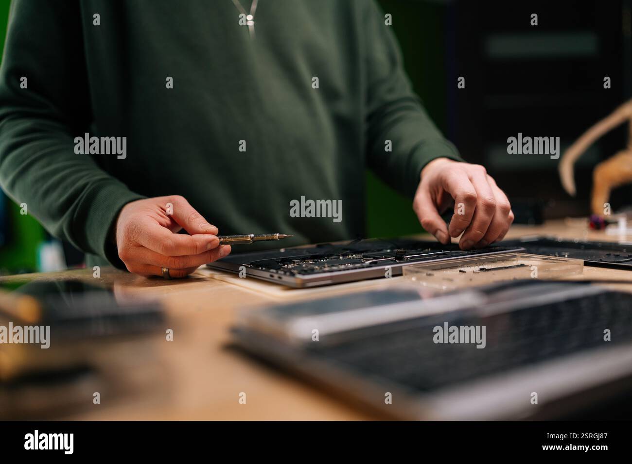 Skilled computer master carefully repairing laptop motherboard, using ...