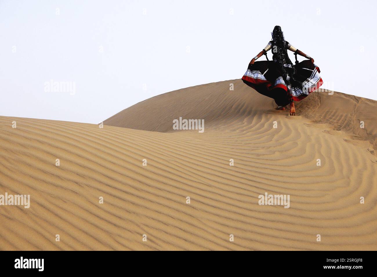 Rajasthani lady walking through sand dunes, Jaisalmer, Rajasthan, India ...