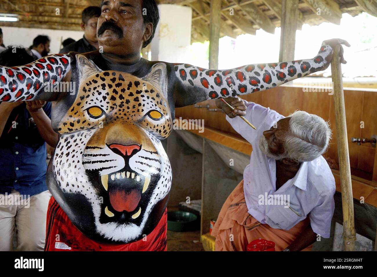 A trained dancer gets his body painted in the colours of a tiger ...