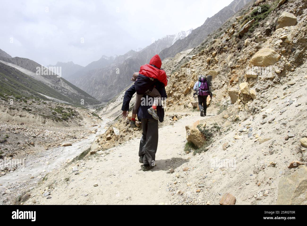 Porter carrying a child Gangotri Uttarakhand India Asia Stock Photo - Alamy
