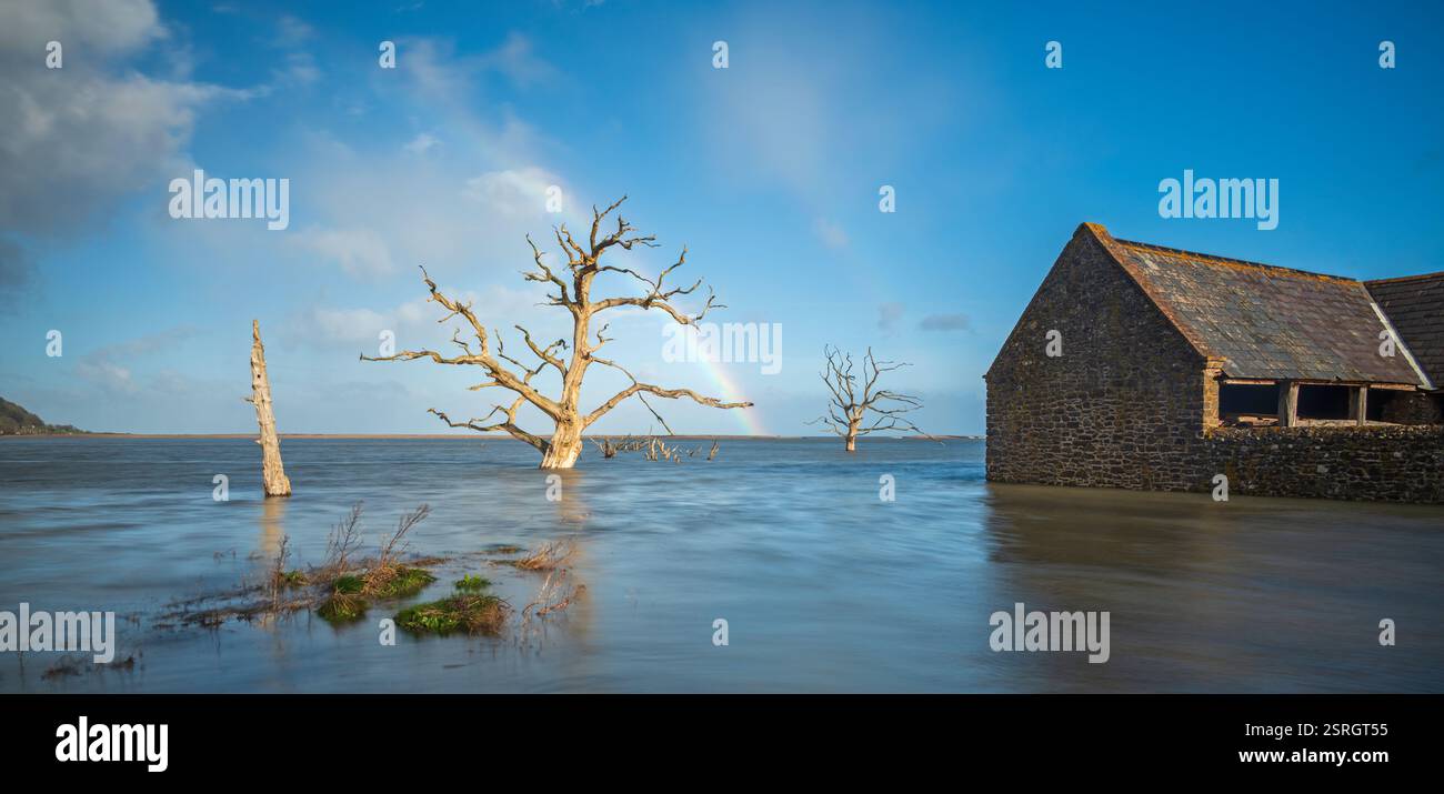 High spring tide flooding the salt marshes with a rainbow across the ...