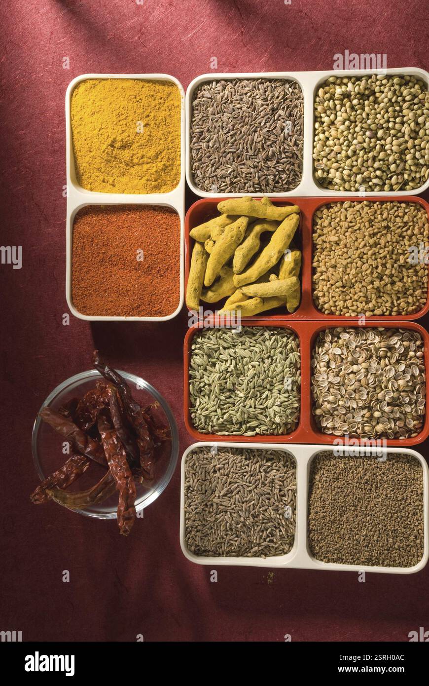 Mix spices in tray on red background Stock Photo - Alamy