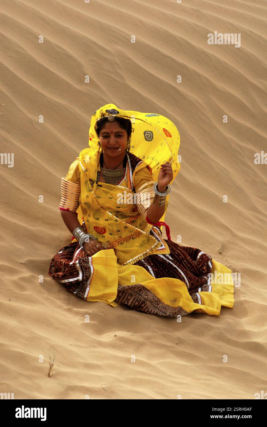 Rajasthani marwari folk singer singing song sitting on sand dune of ...
