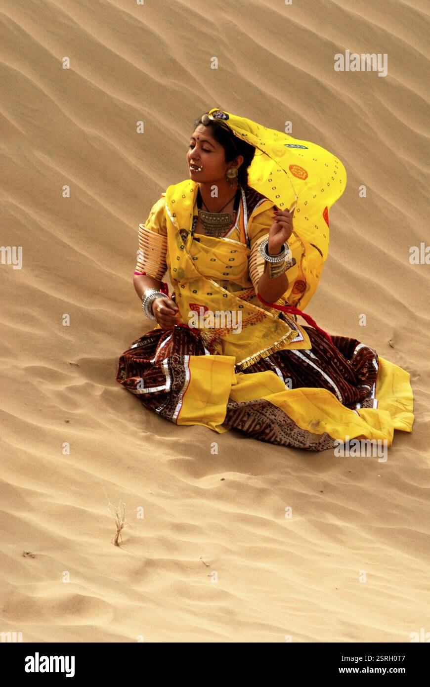 Rajasthani marwari folk singer singing song sitting on sand dune of ...