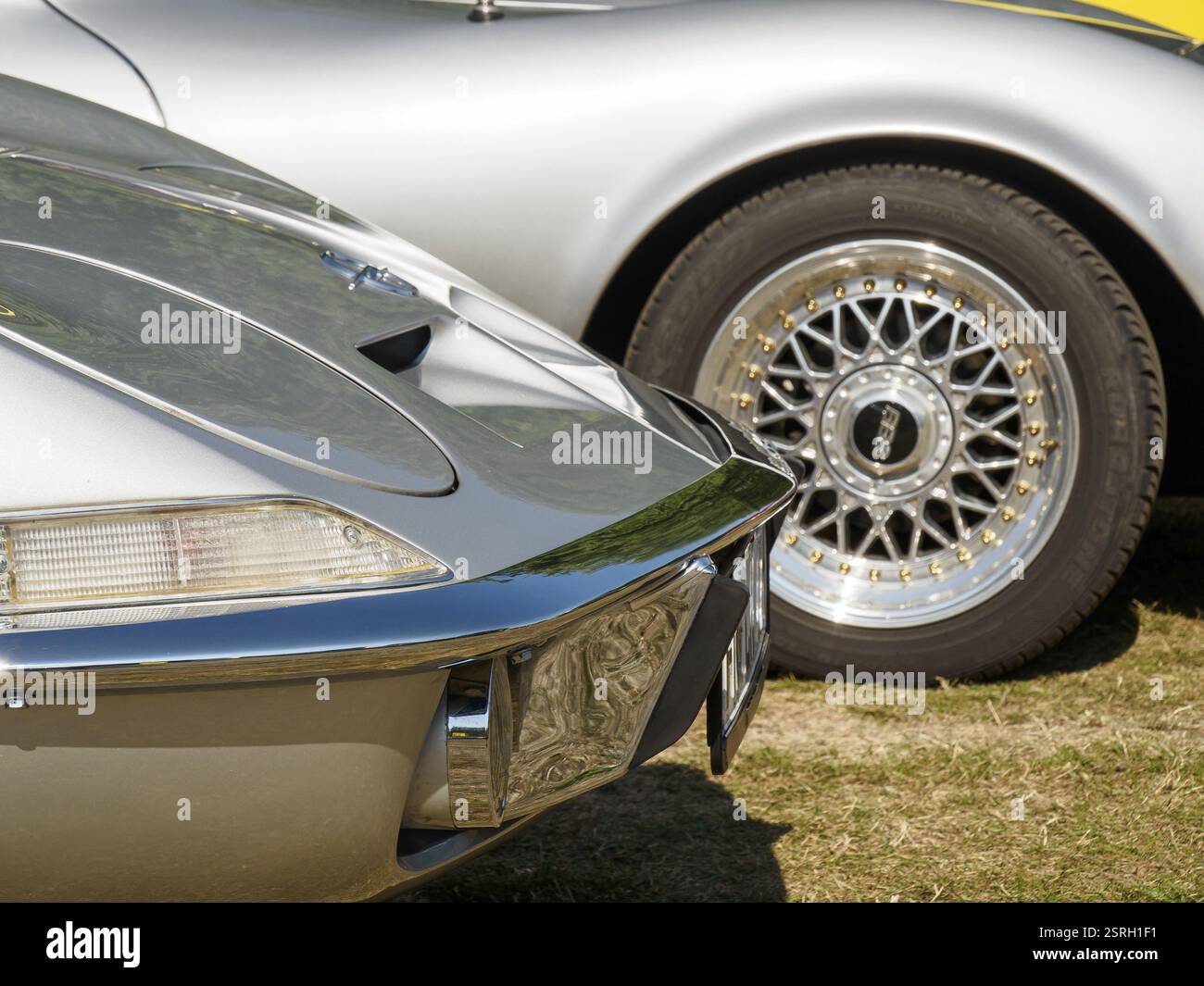 Two classic cars with shiny chrome parts and stylish rims standing side ...