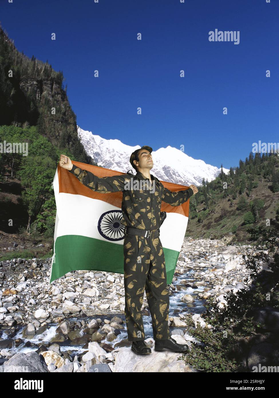 Indian army soldier holding national flag on his backside mountain in ...