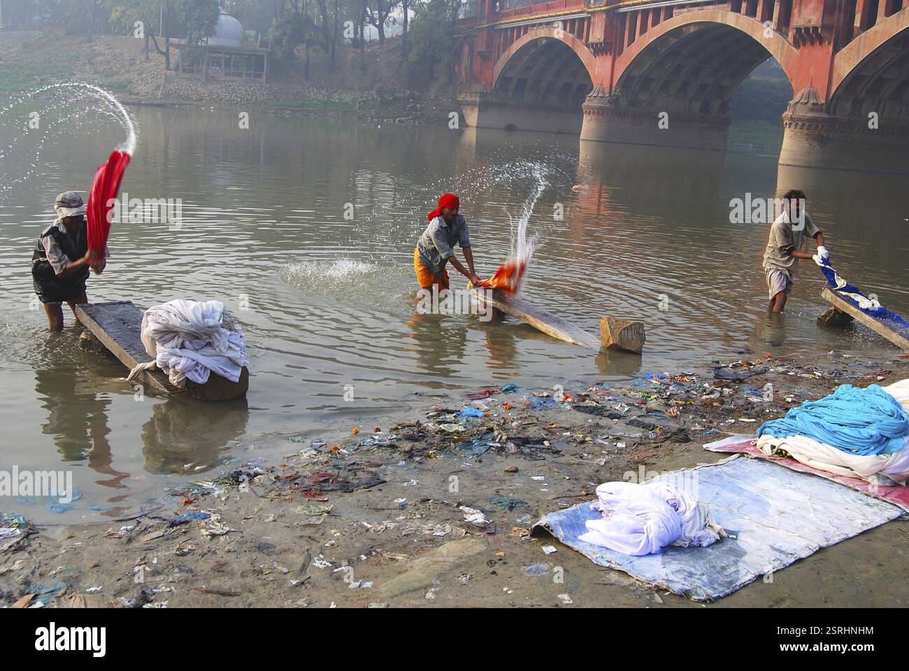 Washer men dhobi washing clothes splash of water drops in air at bank ...