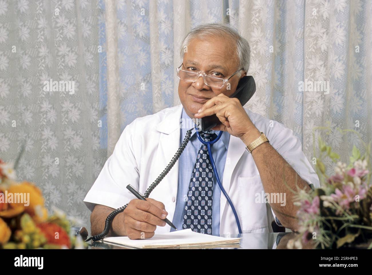 Old age seniors male doctor holding telephone receiver and listening MR ...