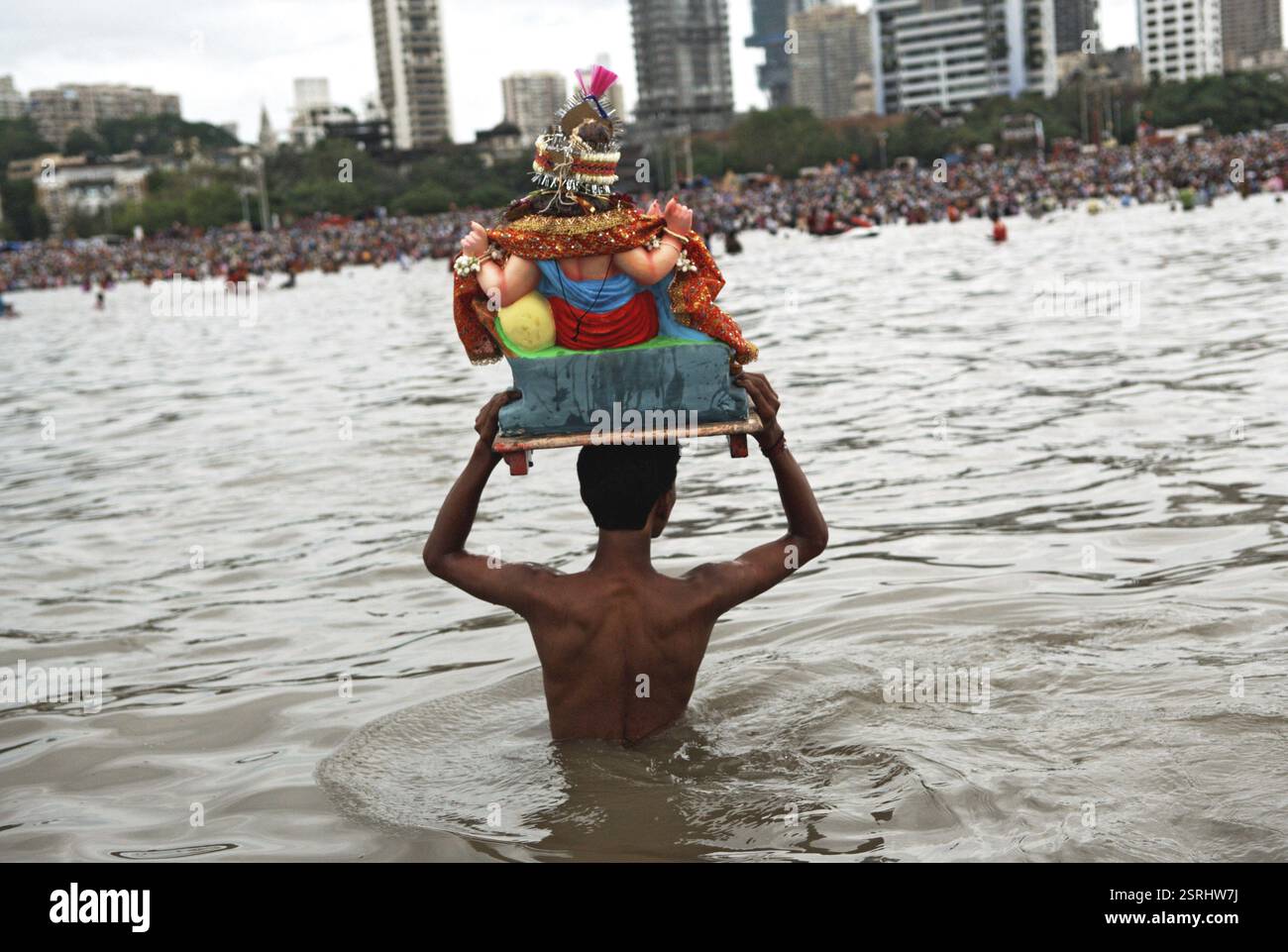 Devotee carrying idol of god ganesh for immersion in girgaum chowpatty ...