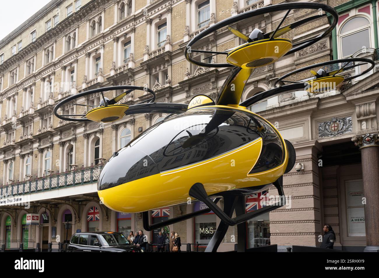 A yellow and black autonomous taxi drone, displayed outside Charing ...