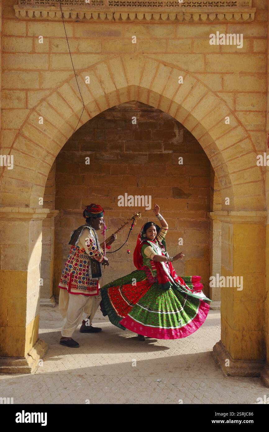 Rajasthani man playing musical instrument and lady dancing at Gadsisar ...