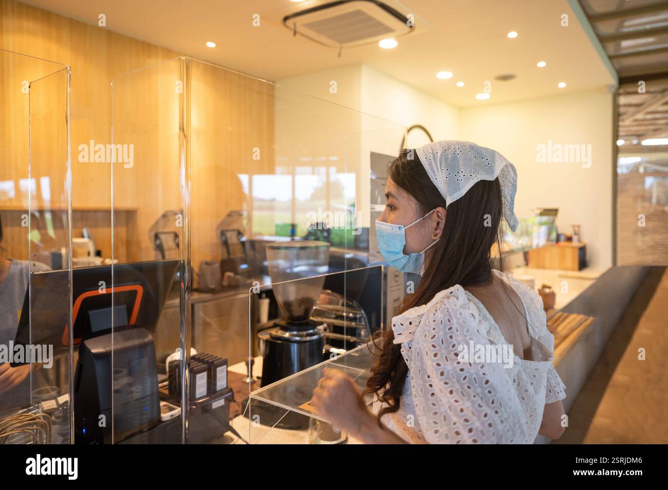 Asian woman wearing face mask ordering beverage on counter bar in ...