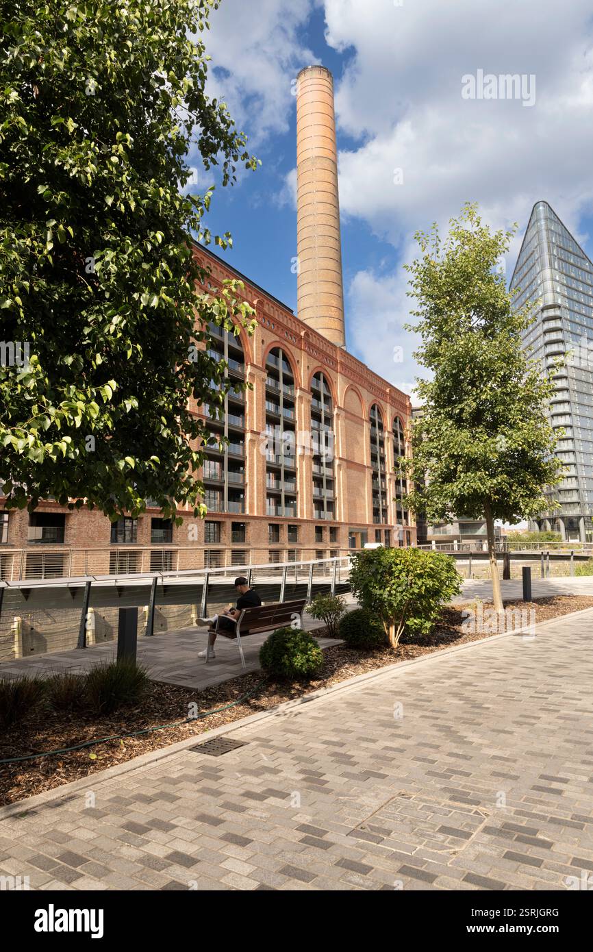 Person sits on bench near converted power station, Lots Road Power ...
