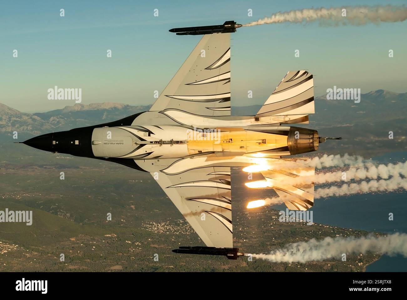 Belgian Air Force F-16 deploying flares in a tactical maneuver. A ...