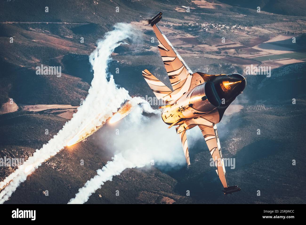 Belgian Air Force F-16 releasing flares in a defense maneuver. A single ...