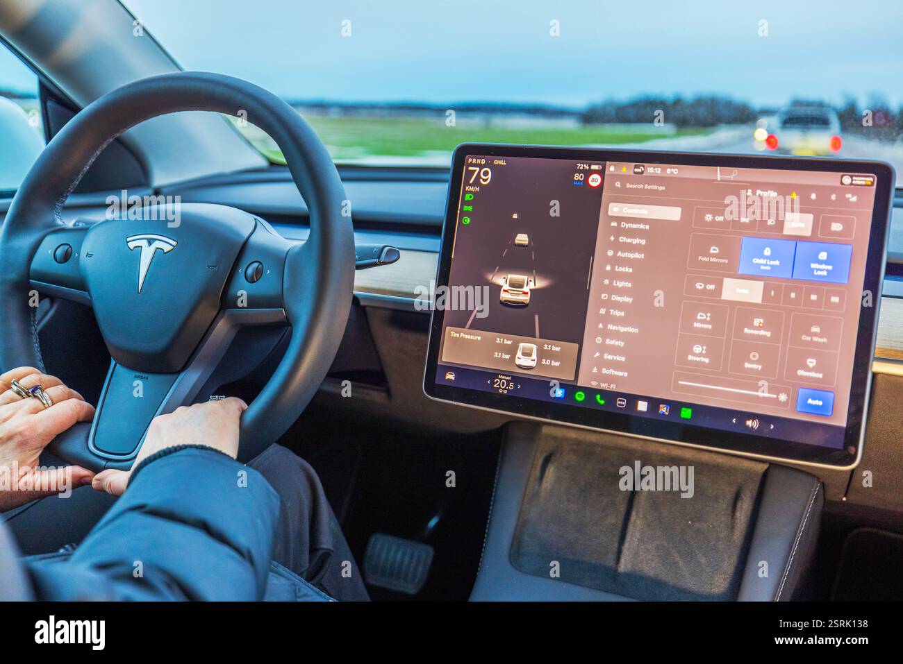 Close up view of Tesla Model Y driver holding steering wheel while ...