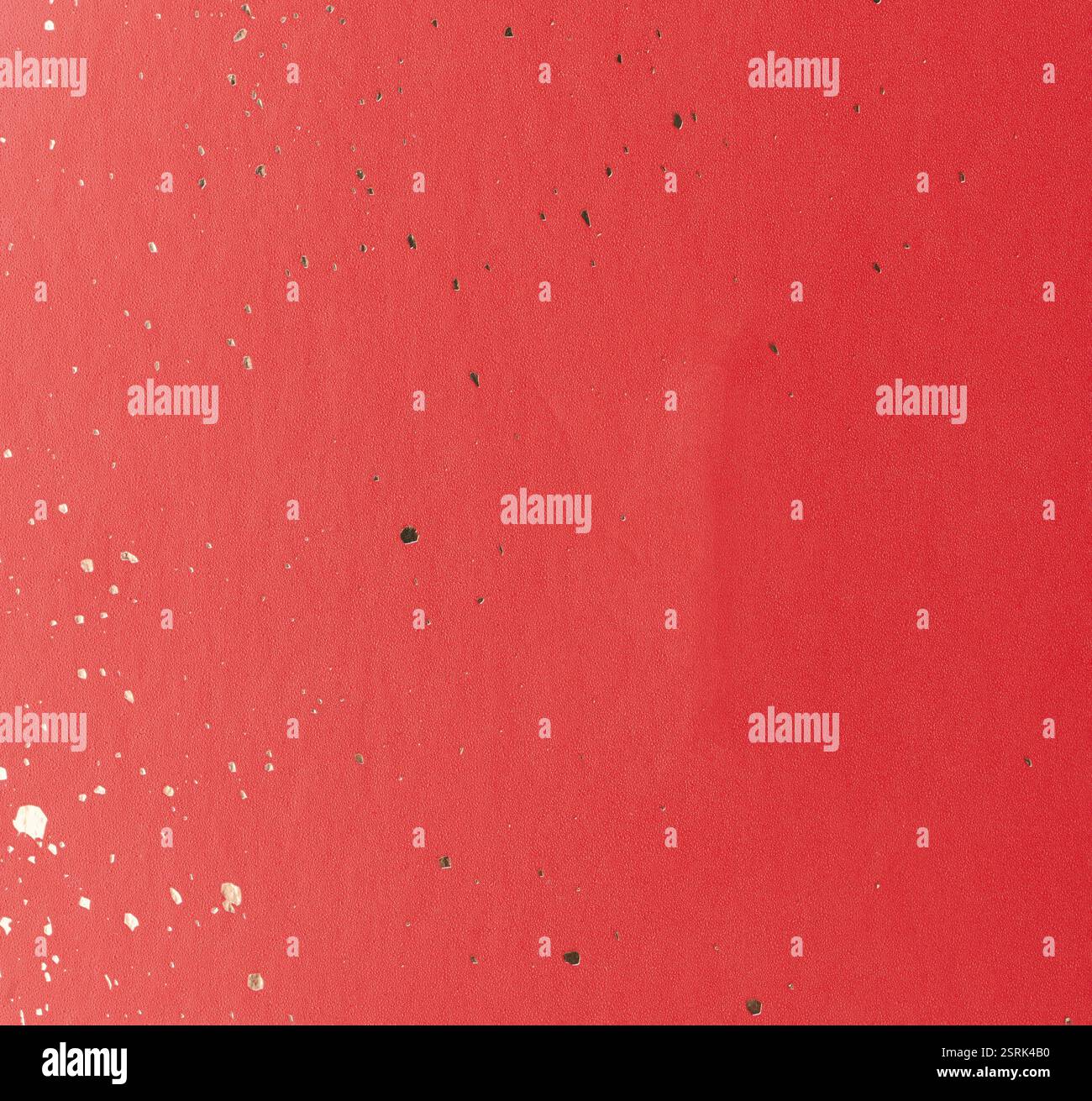 Decorative abstract red matte background with gold metal spots close up ...