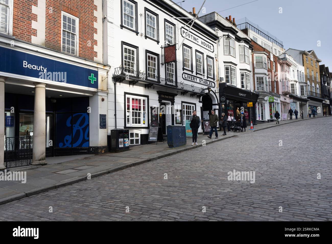 Pedestrians on cobblestone High Street, Guildford, UK. The Angel Hotel ...