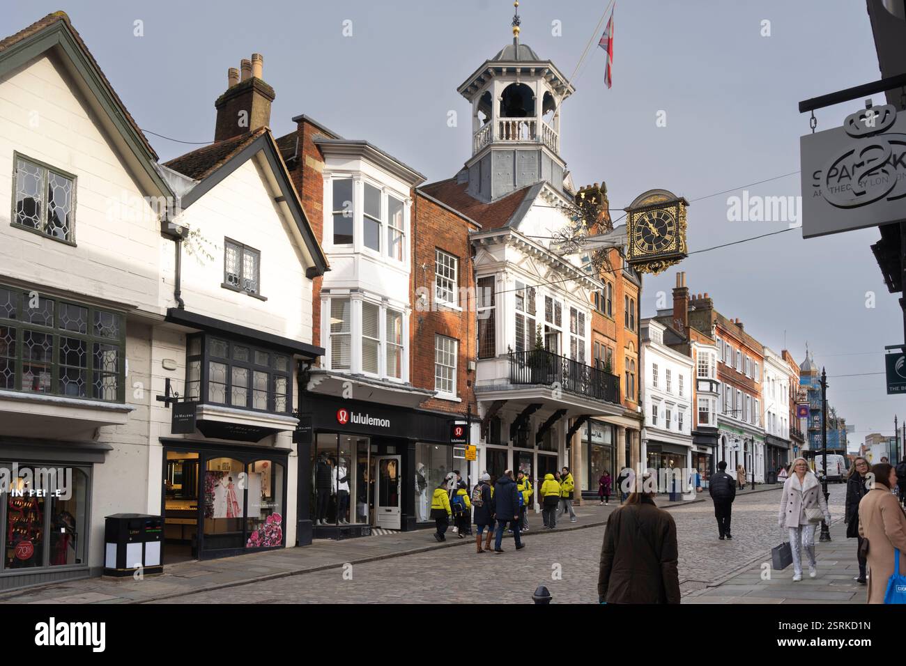 Pedestrians on High Street, Guildford UK. Historic buildings line the ...