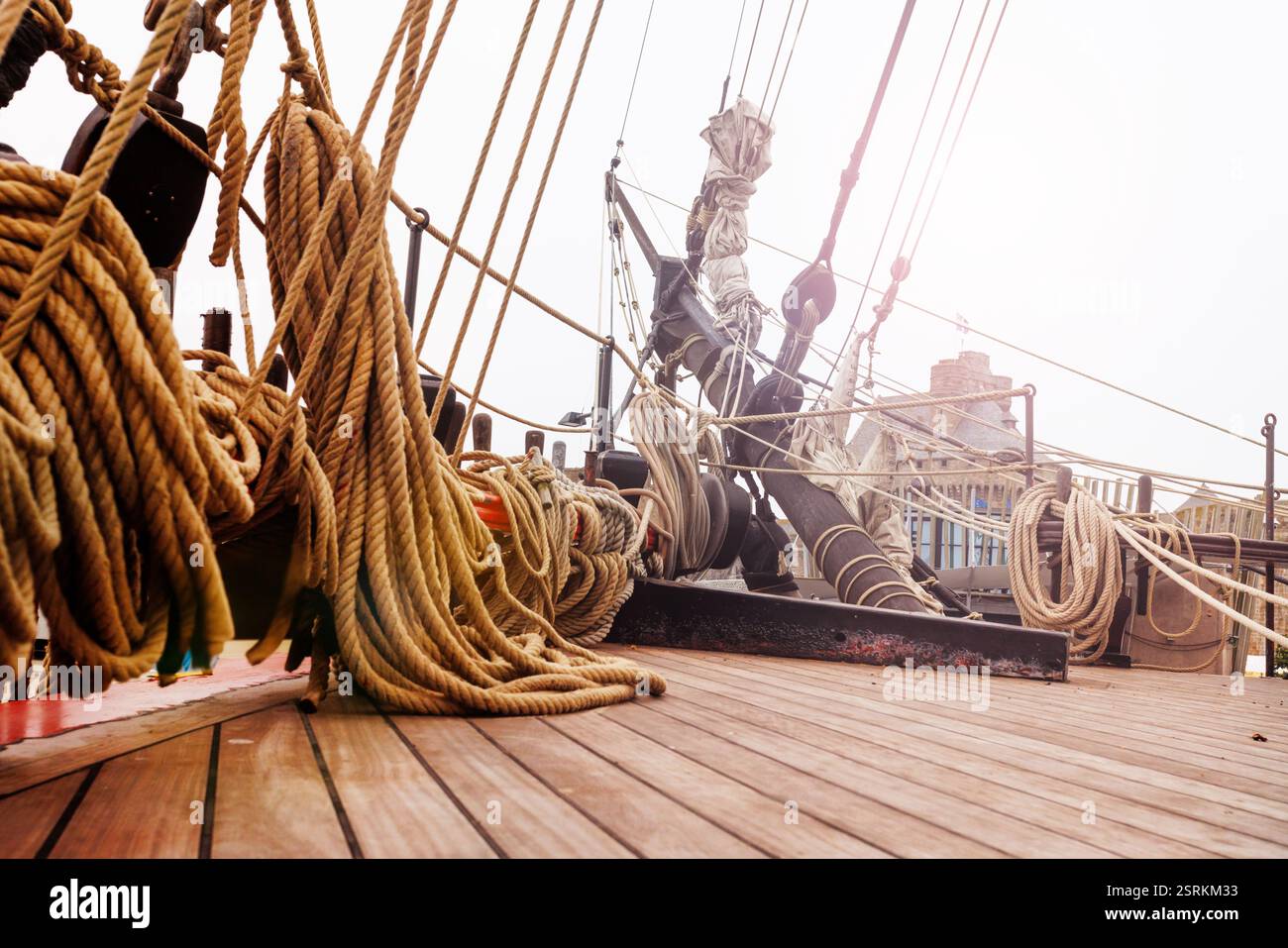 Ropes hanging in organized loops on the sunlit side of the large ...