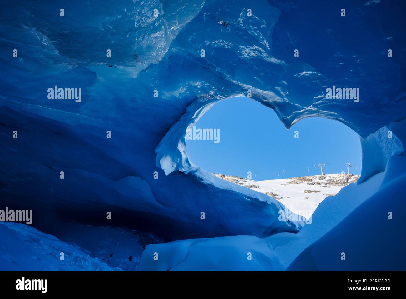 Blue ice cave and mountains through heart-shape entrance Stock Photo ...