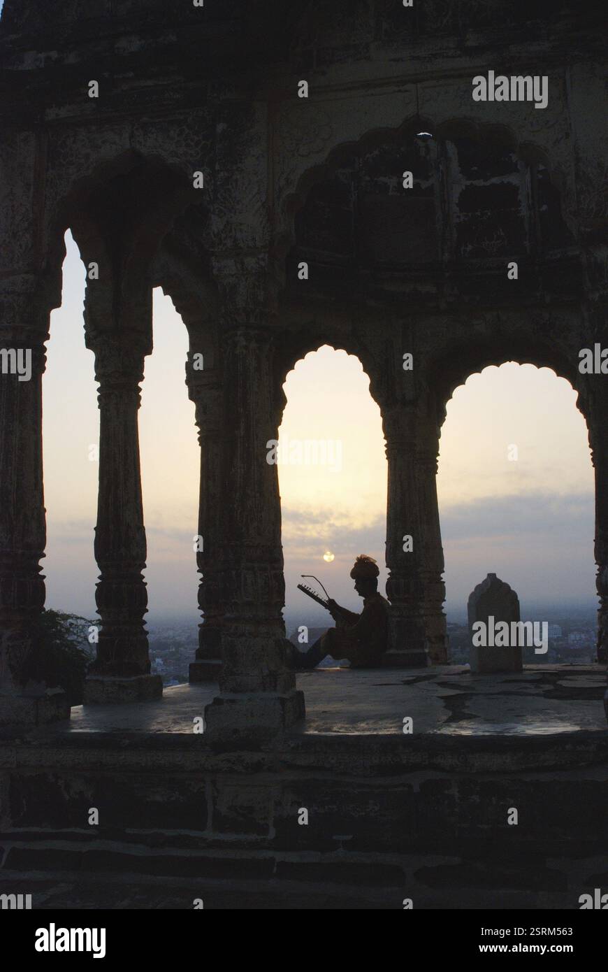 Folksinger playing ravanhatta at sunrise in cenotaph, Rajasthan, India ...