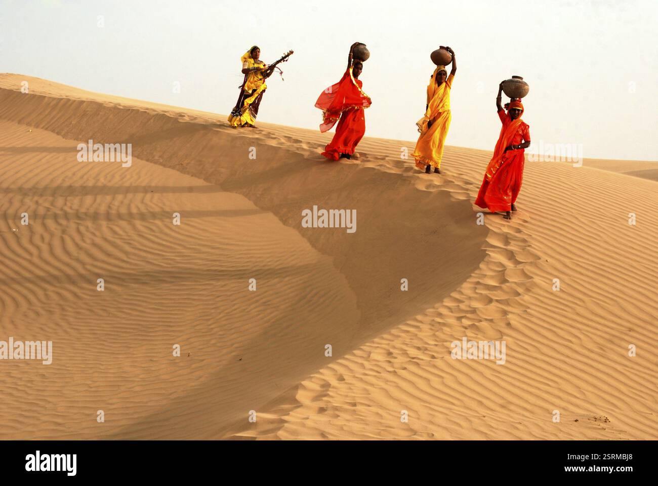 Rajasthani women with pitchers on head and one playing ravanhatta ...