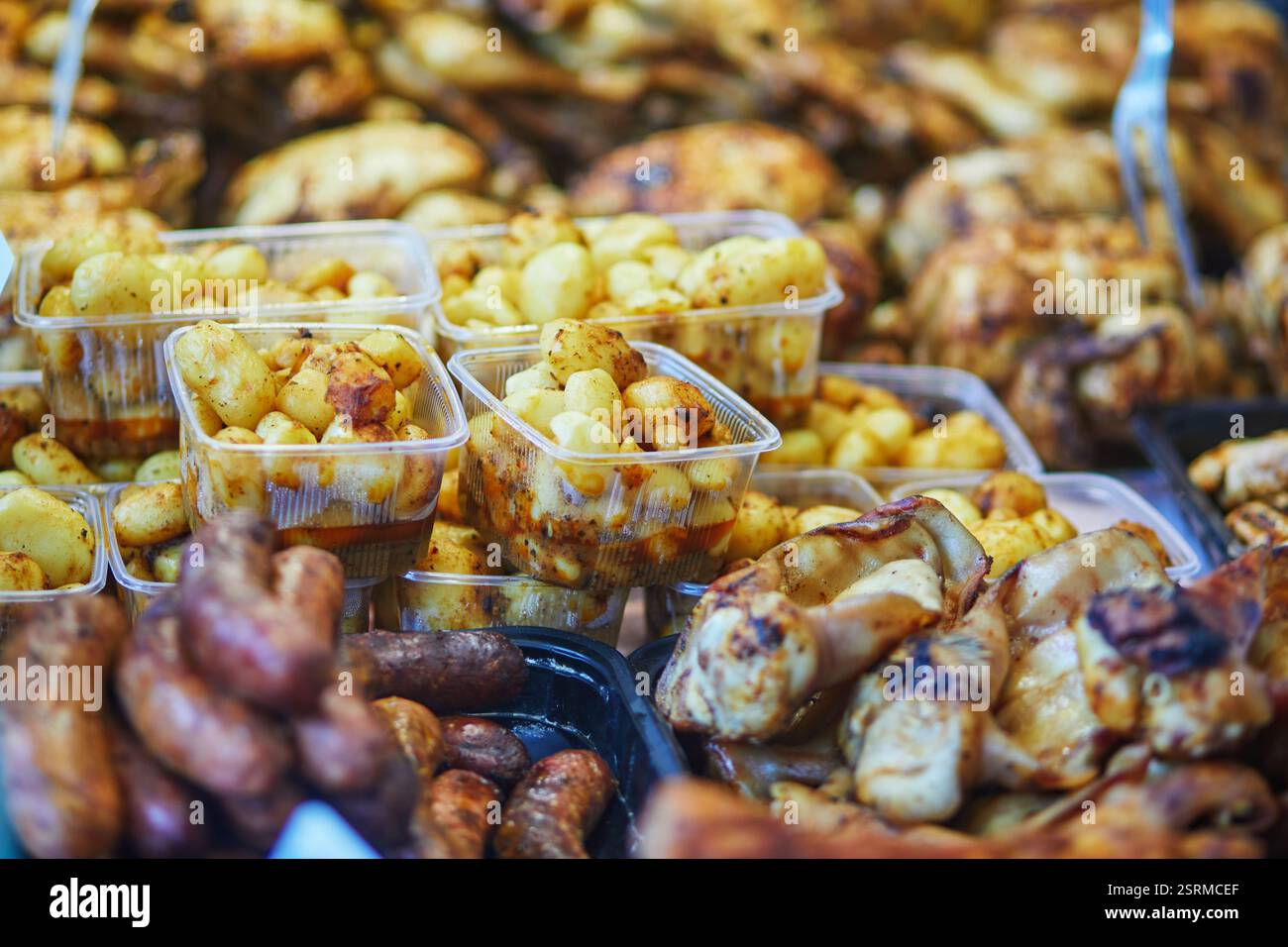 Baked potatoes and fried chicken, pork and suasages on a farmer market ...