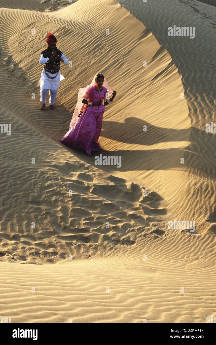 Rajasthani woman and folk musician crossing sand dunes, Khuhri ...